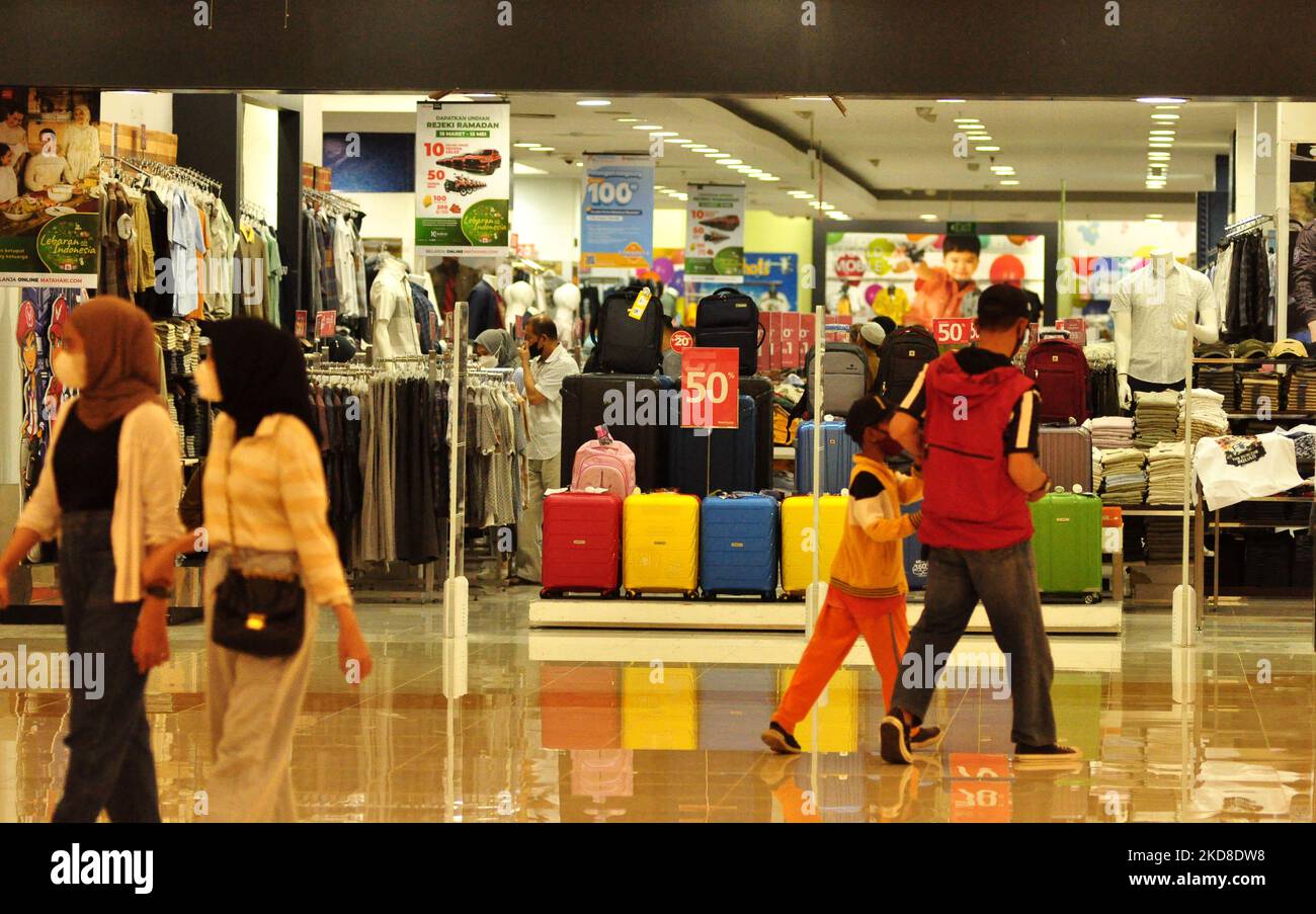 Residents wearing health masks walk in a shopping center ahead of Eid ...