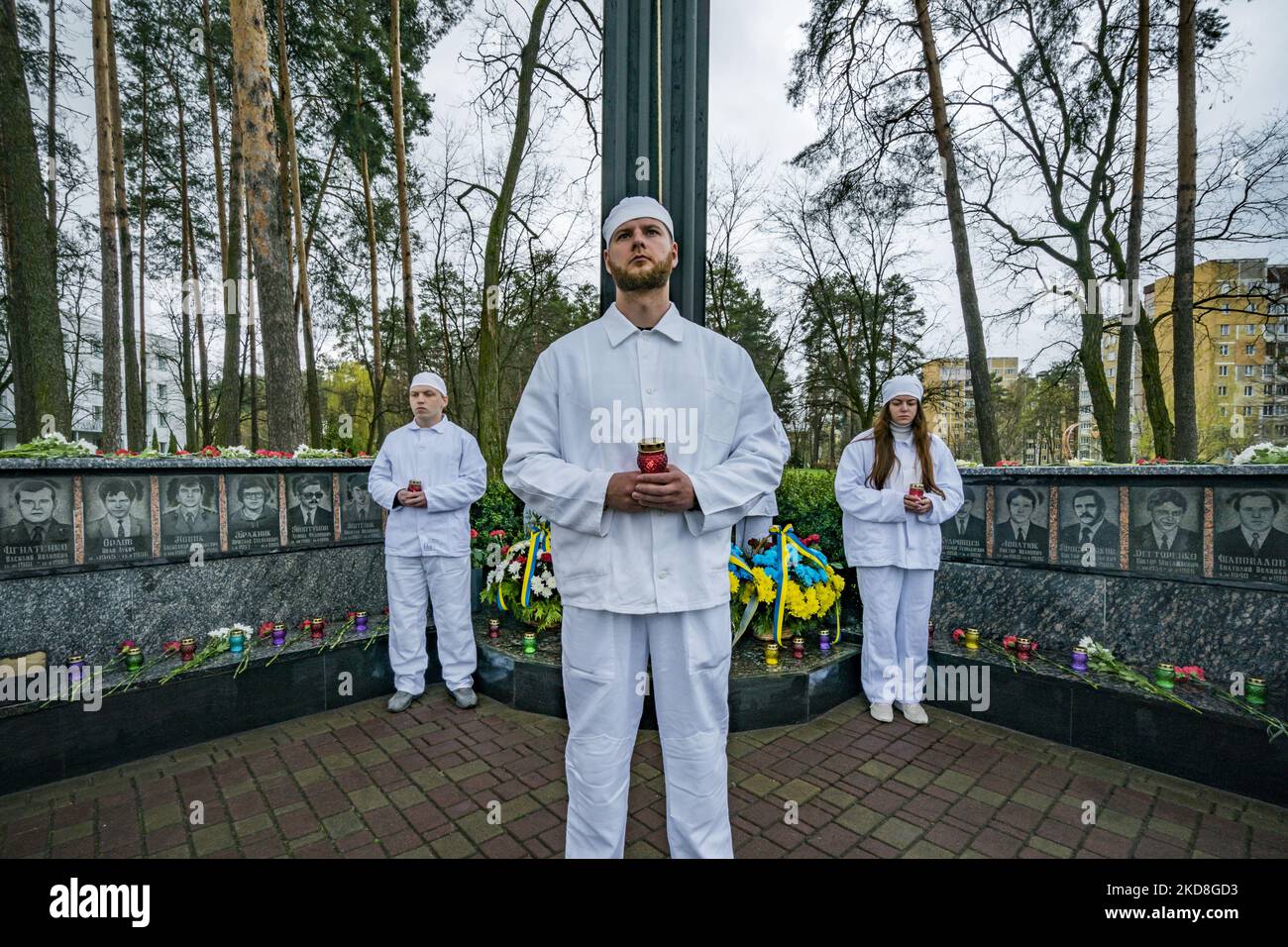 People dressed like workers of the Chernobyl Nuclear Plant hold candles ...