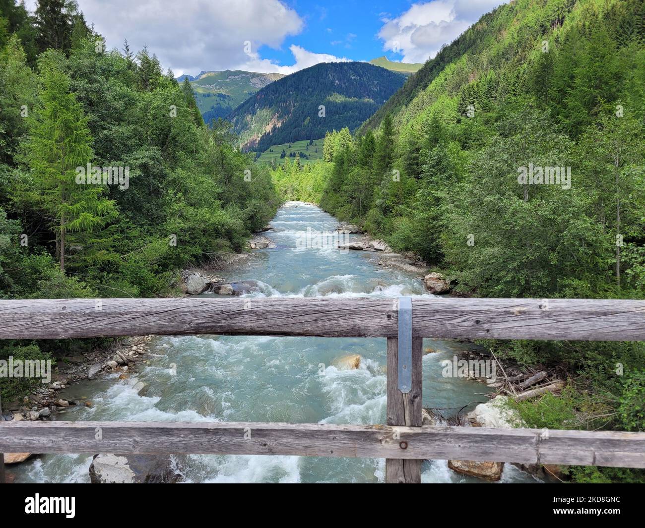 A scenic view of a river flowing between trees on a sunny day in ...