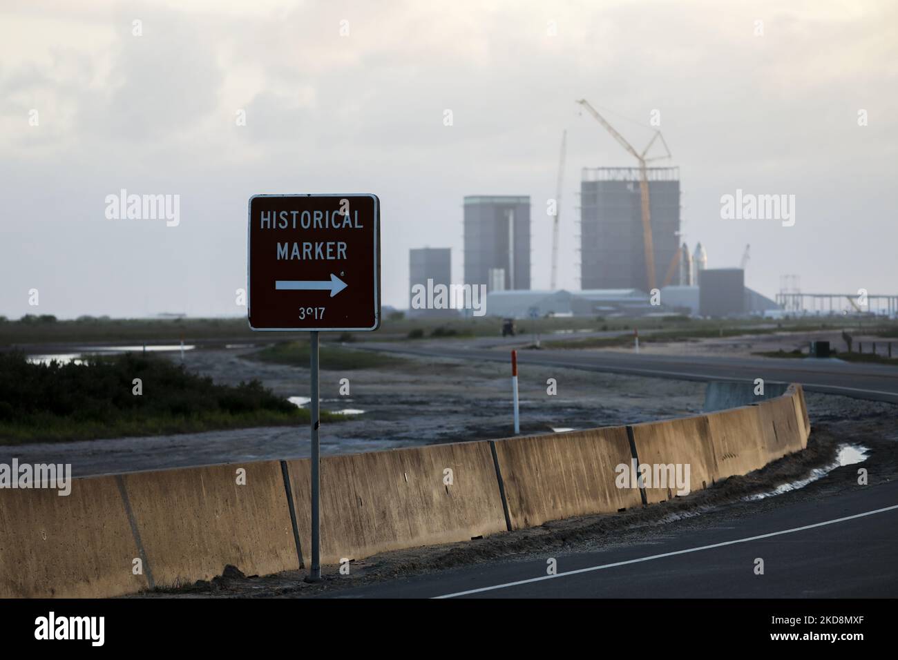 SpaceX's build site is seen in the distance behind a Historical Marker ...