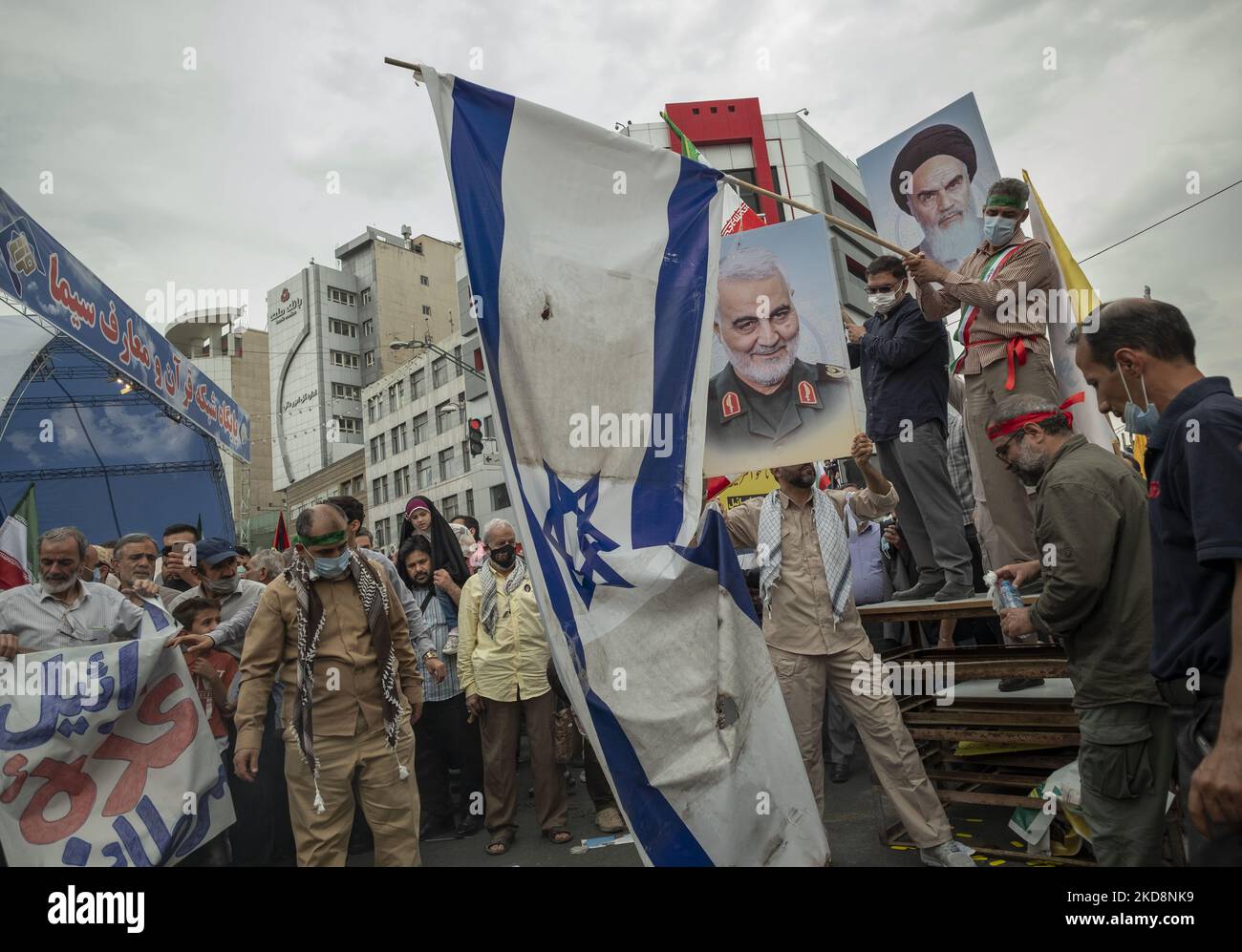 Iranian demonstrators preparing an Israeli flag to set on fire as the ...