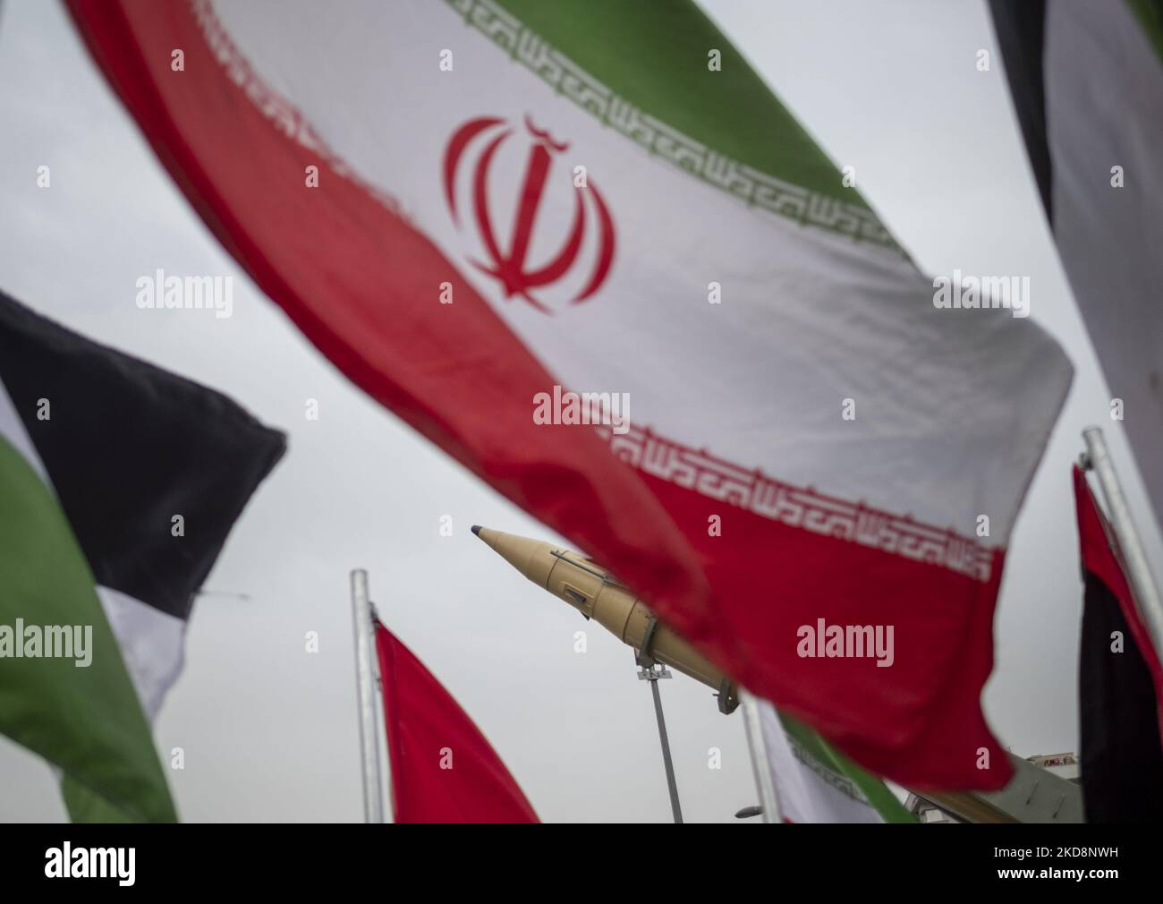 An Iran’s flag waves next to an Iranian Emad Surface-to-Surface missile ...