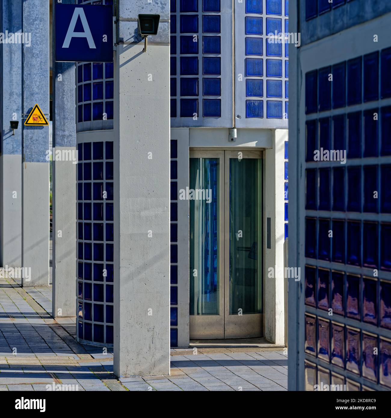 Blue colored glass block corridor and elevator door Stock Photo - Alamy