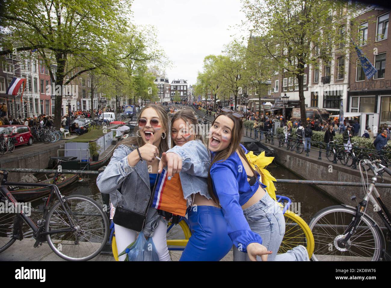 Three young Dutch girls with the Dutch flag painted on their faces pose ...