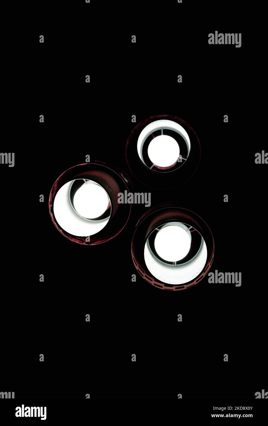 a vertical shot of three light bulbs against a dark background Stock ...