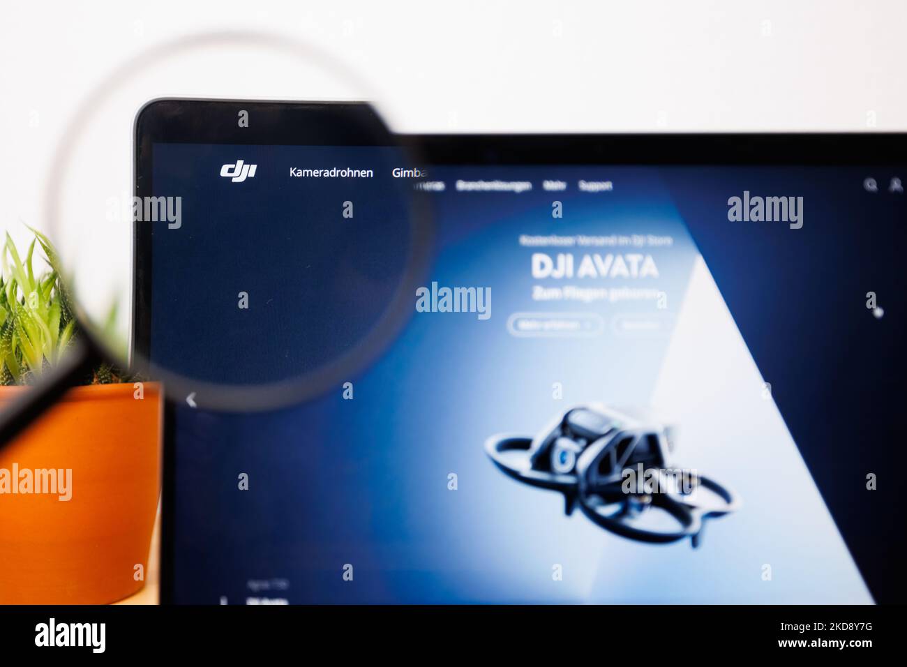 A DJI Avata Logo under a magnifying glass. DJI Avata Website on Laptop ...