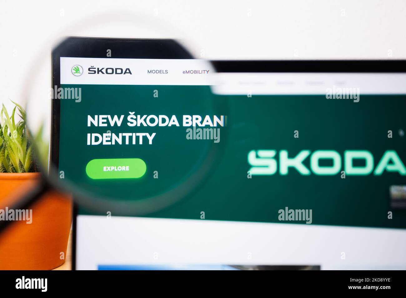 A SCODA Logo under a magnifying glass. SCODA Website on a Laptop screen ...