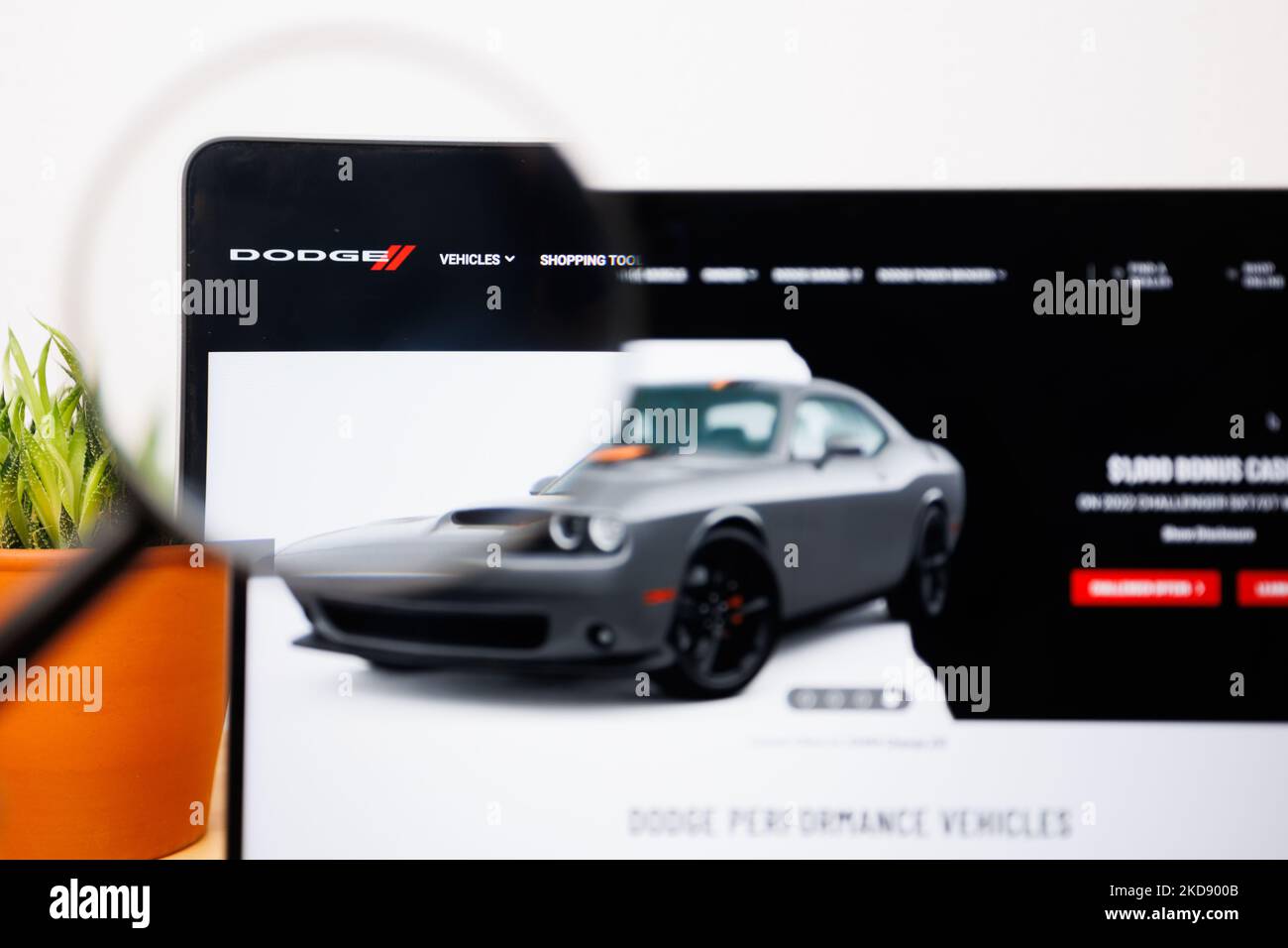 A dodge Logo under a magnifying glass, dodge Website on a Laptop screen ...