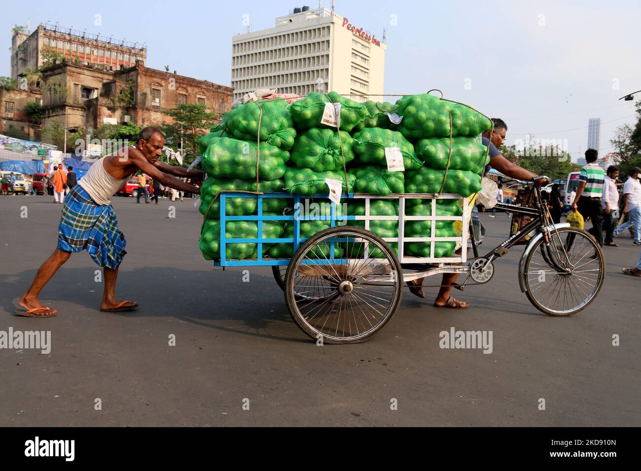 Indian Laborers push a cycle van loaded Mosambi fruits items across the ...