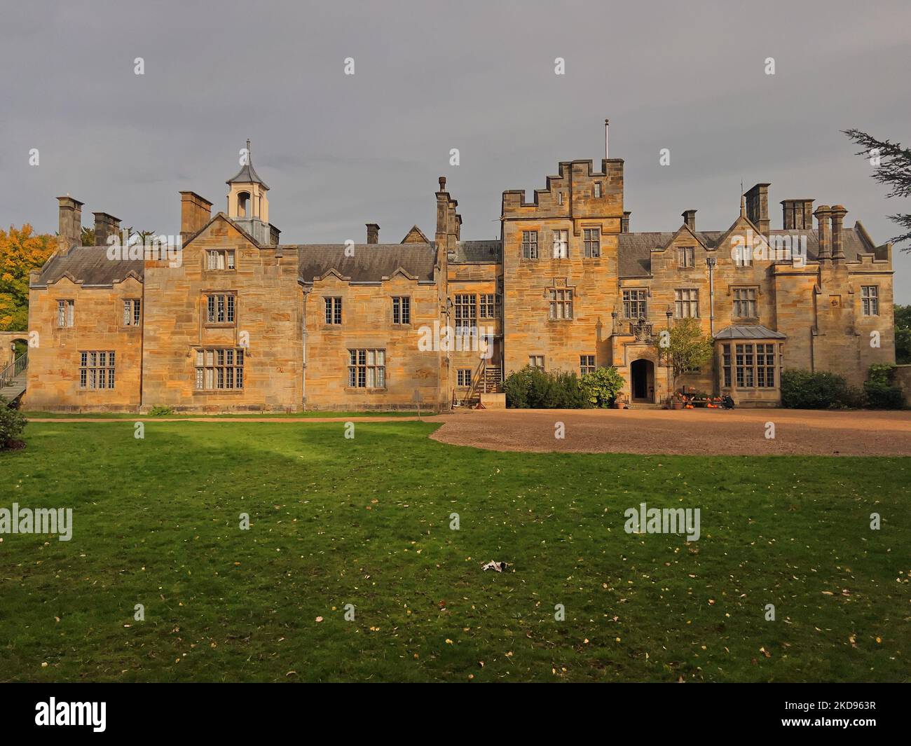 The exterior design of an old castle with grass landscape and gray sky ...