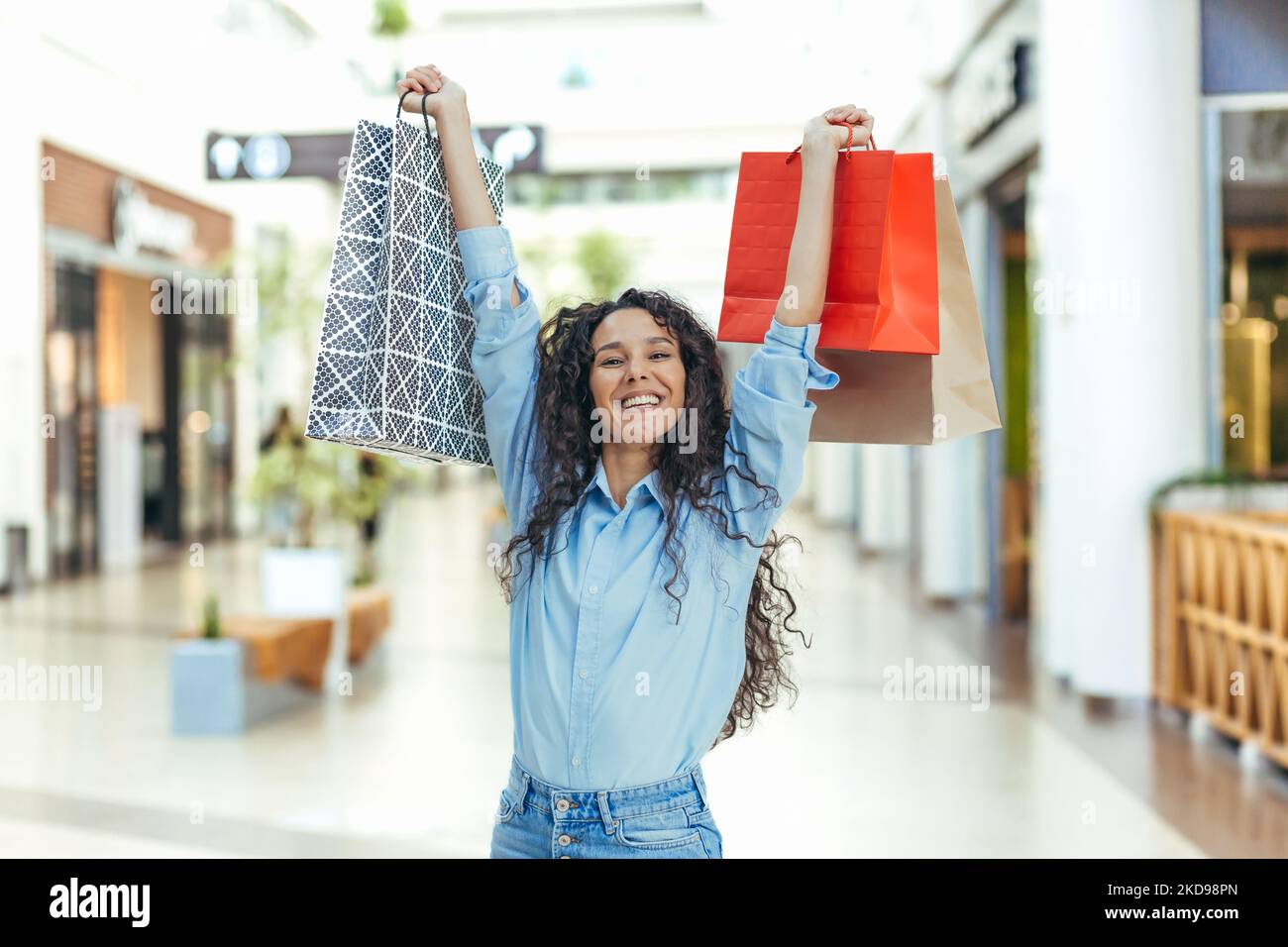 Portrait of a happy woman shopper, Hispanic woman in a supermarket with ...