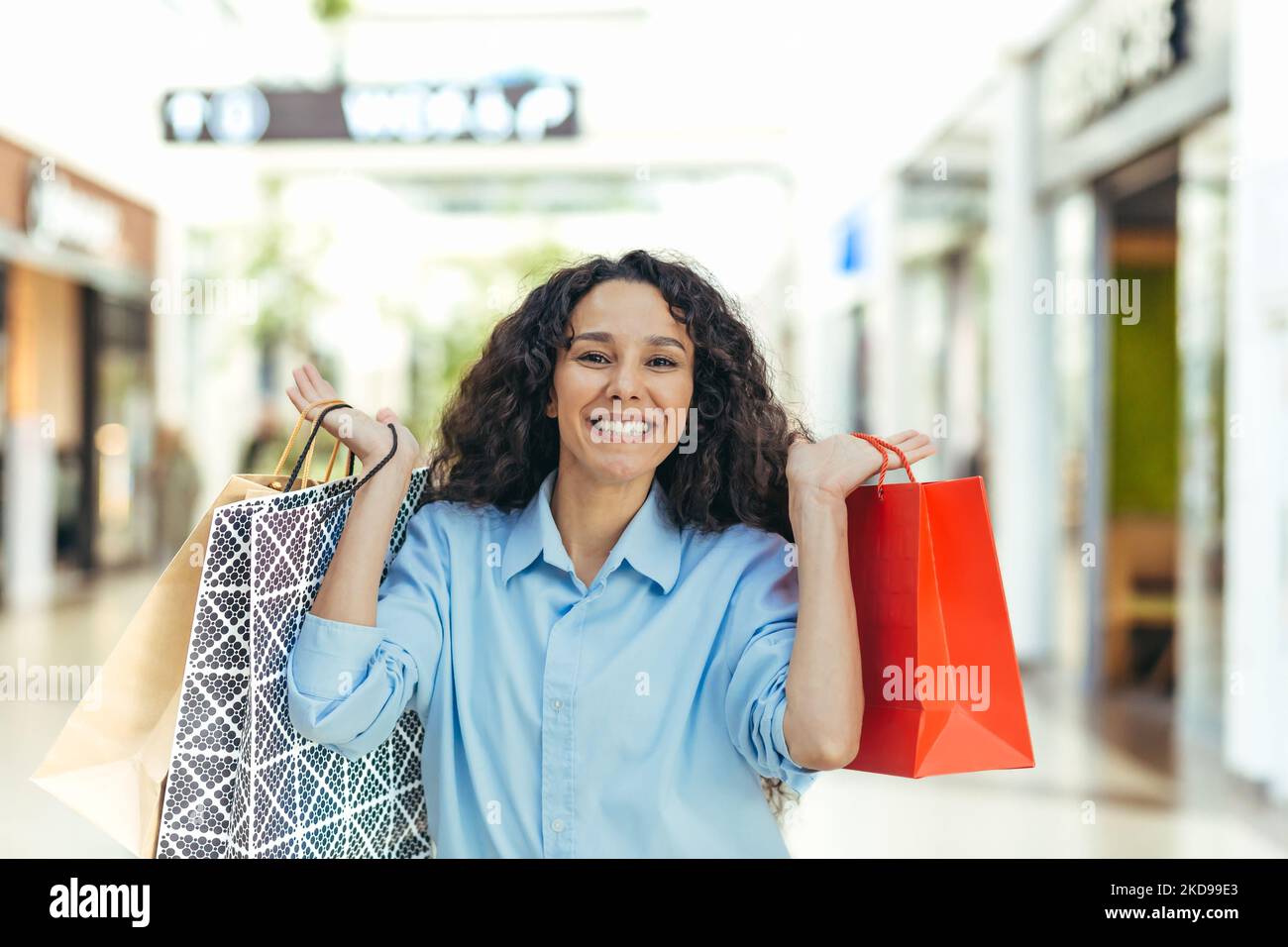 Portrait of a happy woman shopper, Hispanic woman in a supermarket with ...