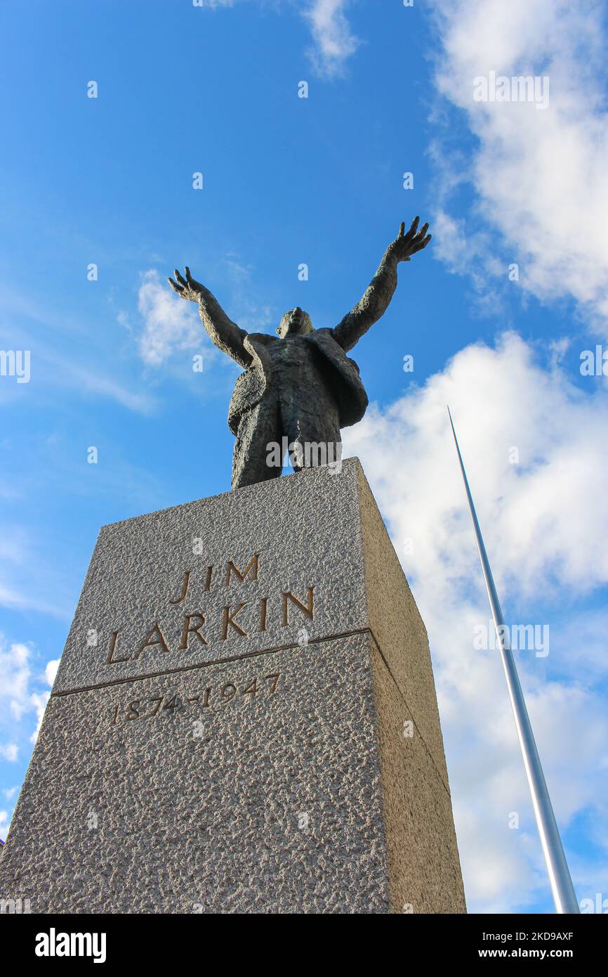 A vertical low-angle shot of Jim Larkin statue and The Spire of Dublin ...