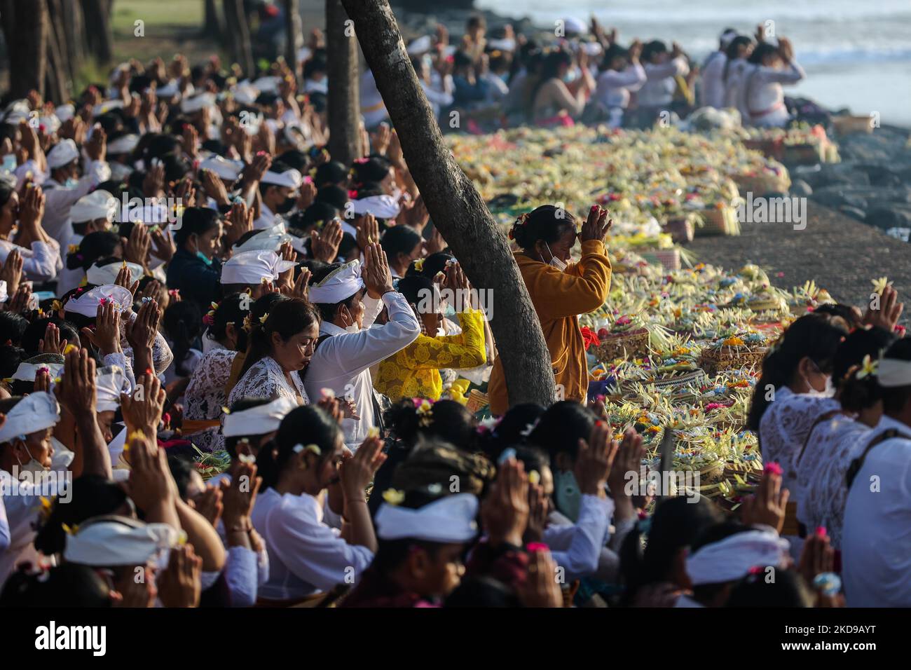 Balinese Hindu devotees gather as they perform prayers during the ...