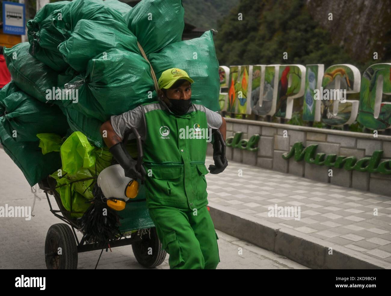 A city worker is pulling a trolley with bags in Aguas Calientes. On ...
