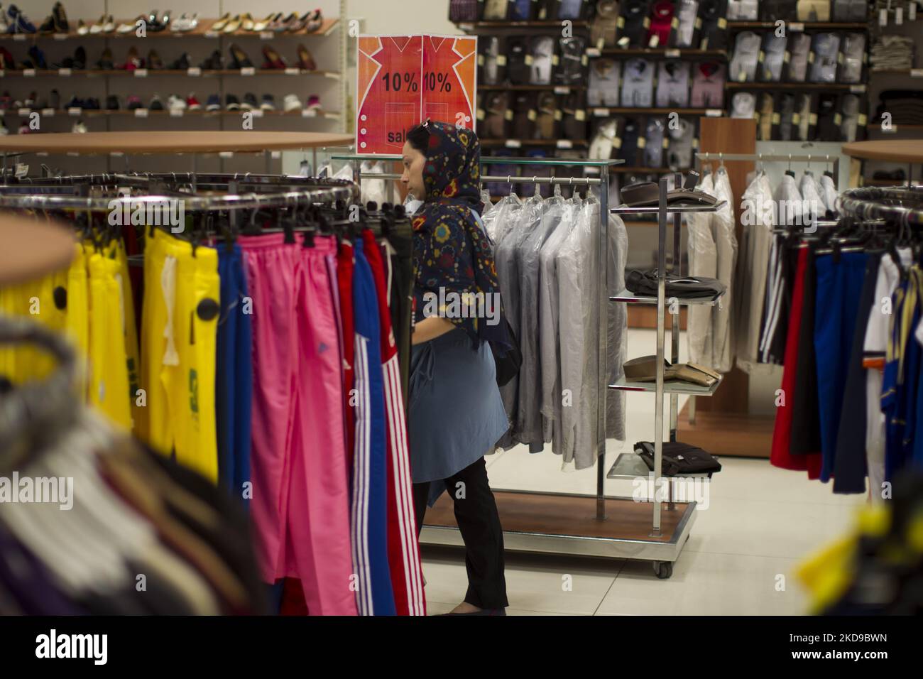 An Iranian woman walks through dress stands in Tehran's Megamall on ...