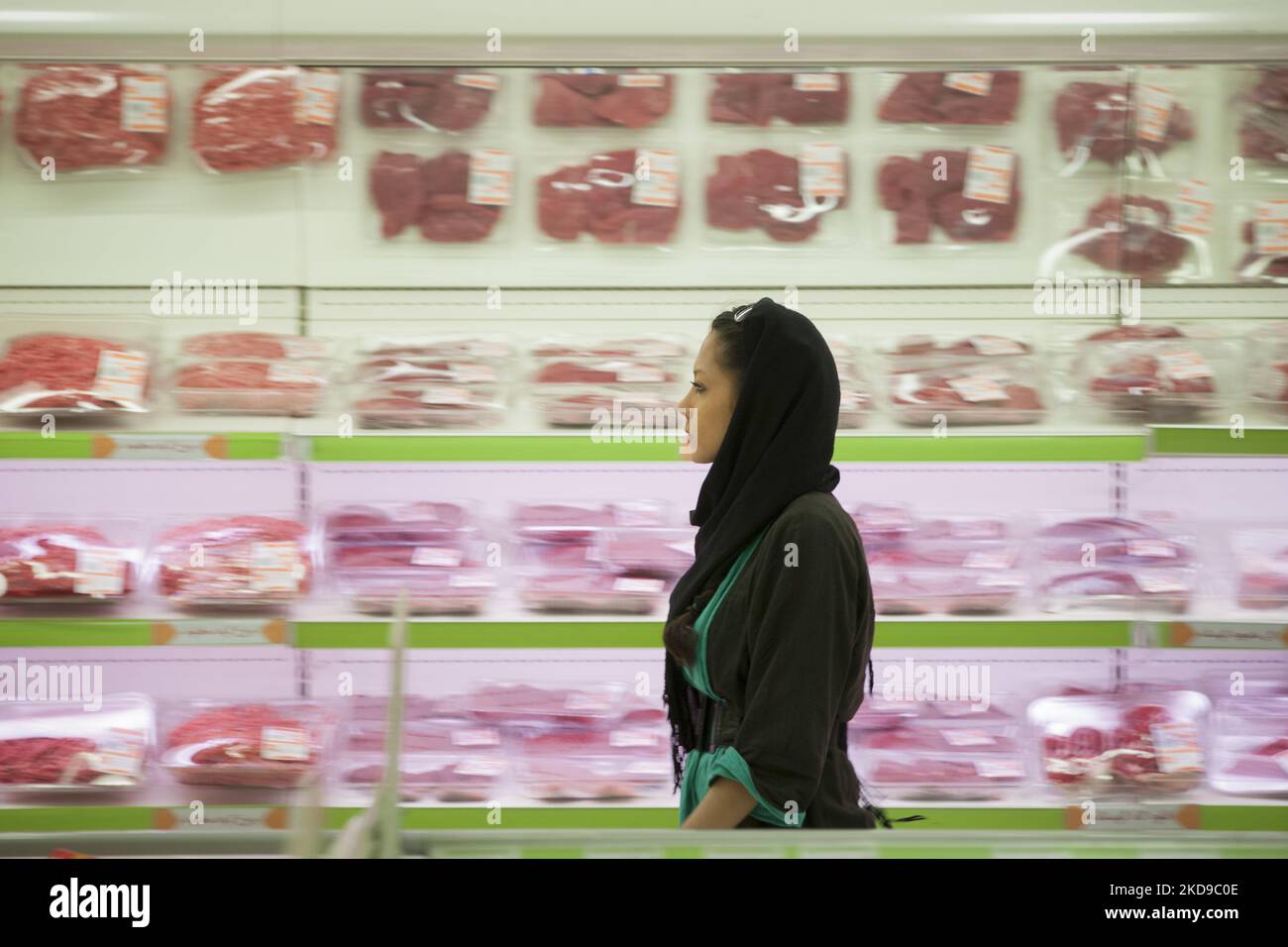 An Iranian woman walks past shelves of meats in Tehran's Megamall on ...