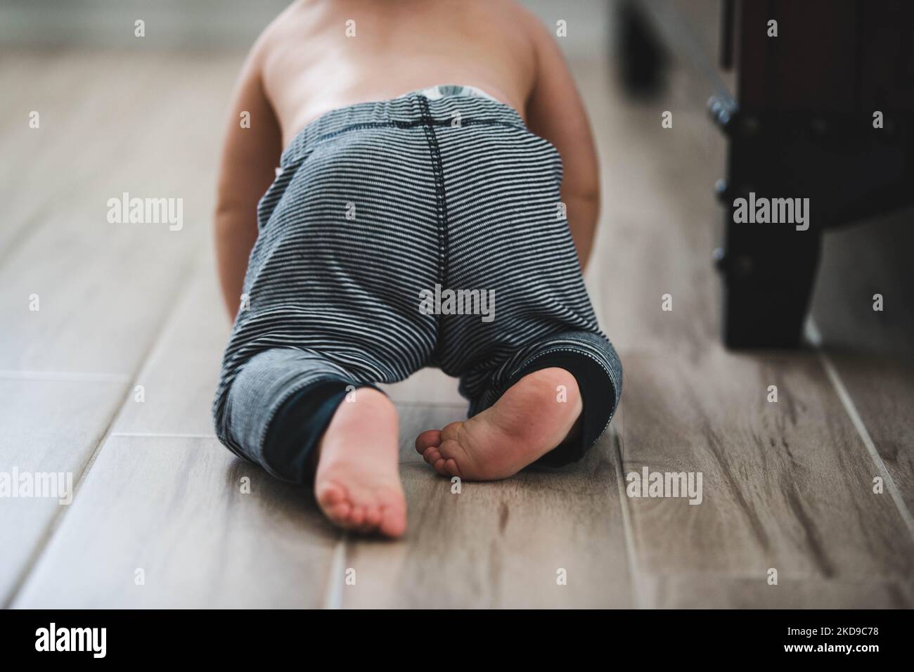 A child creep on all fours on warm wooden floor at home Stock Photo - Alamy
