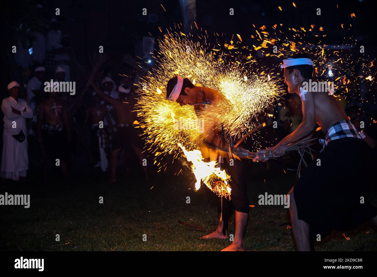 A Balinese man is hit with burning dried coconut leaves during a fire ...