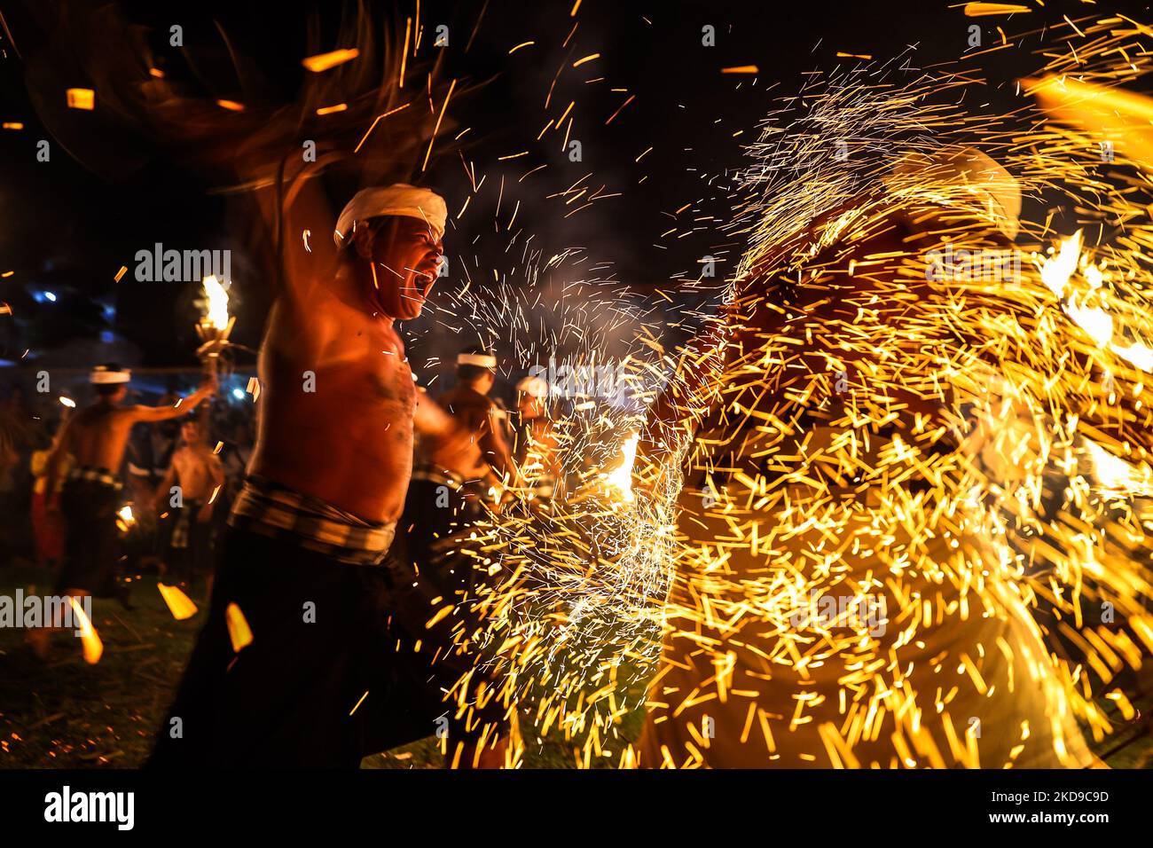 A Balinese man is hit with burning dried coconut leaves during a fire ...