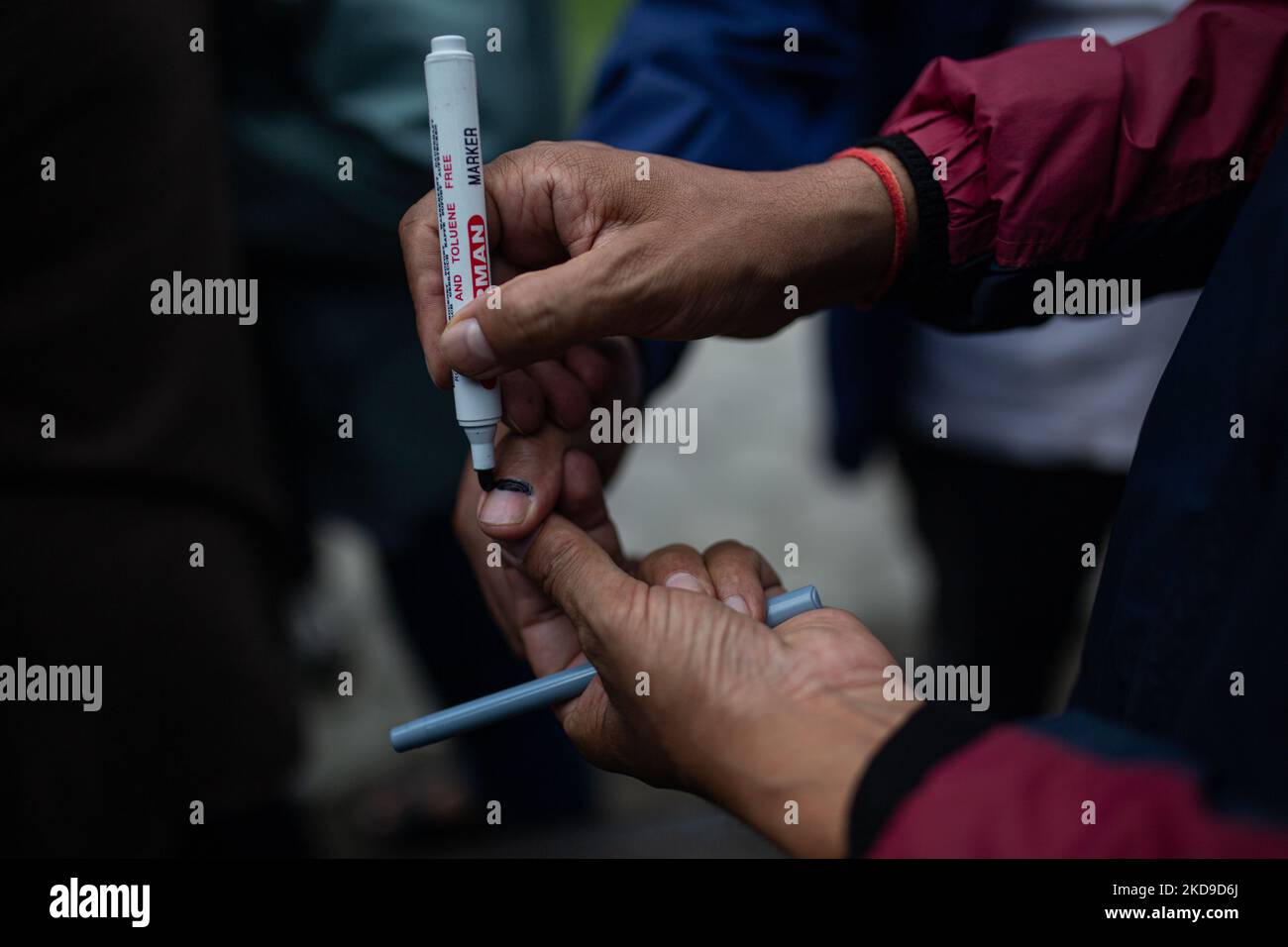 A person is marked with indelible ink by an official during a mock ...