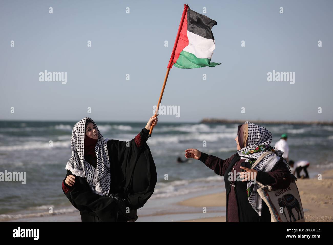 Palestinians gather with national flags along a beach as they mark ...