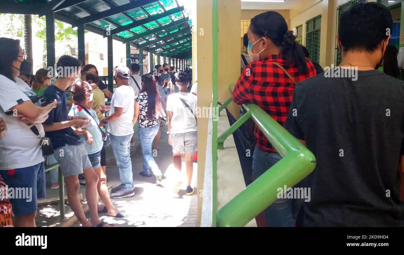 Filipinos wait in line to cast their votes for the 2022 national and ...