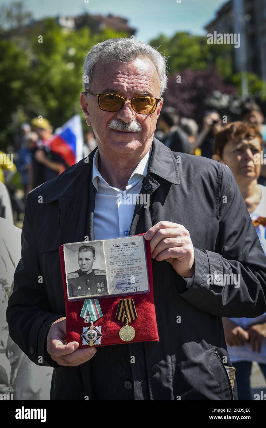 Man holds portrait in front of the Soviet Army monument during Victory ...