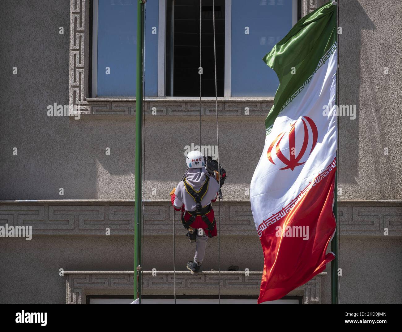 A female member of the Iranian Red Crescent Society climbs down a ...