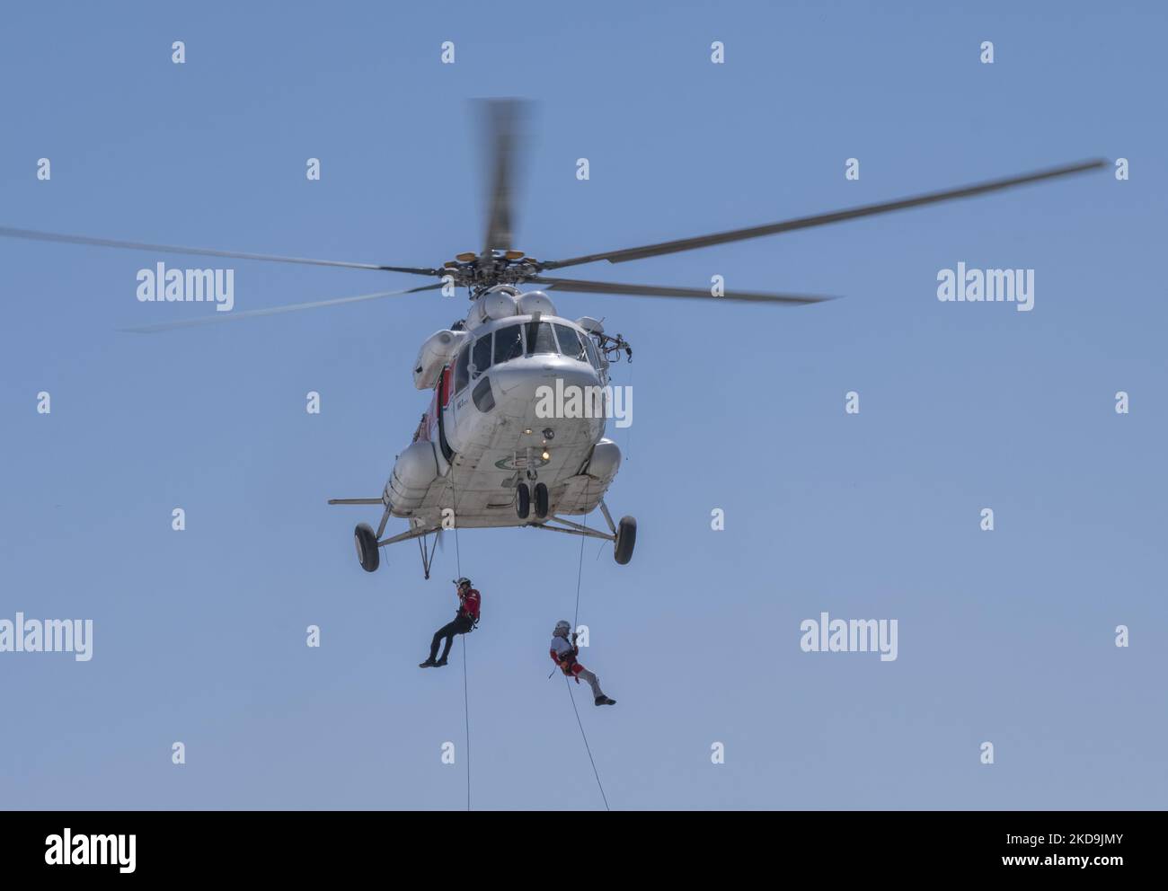 Two members of the Iranian Red Crescent Society climbs down from a ...