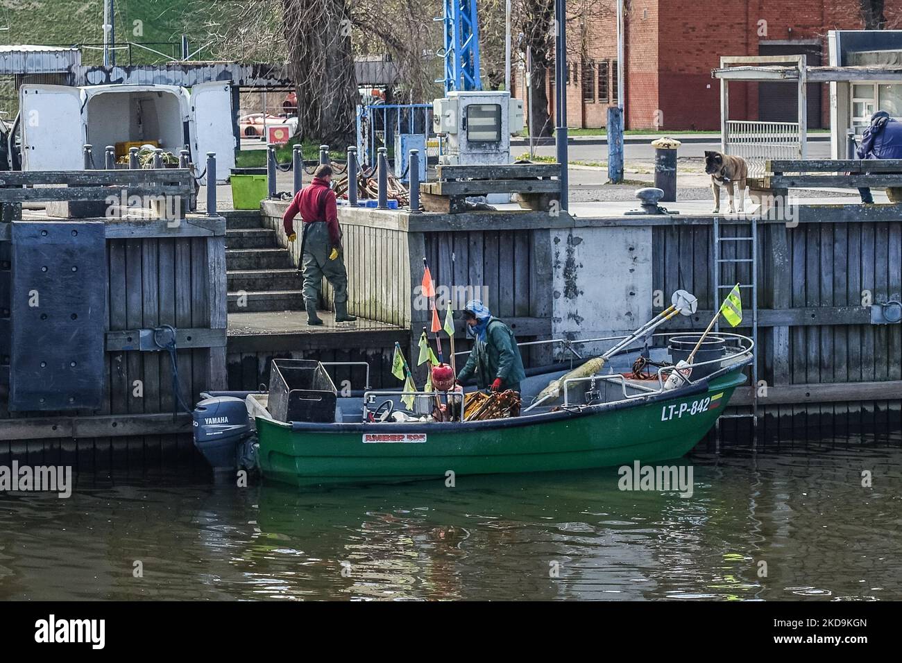 Fishermen unloading their fishing boat on the Akmena - Dane (Dange ...