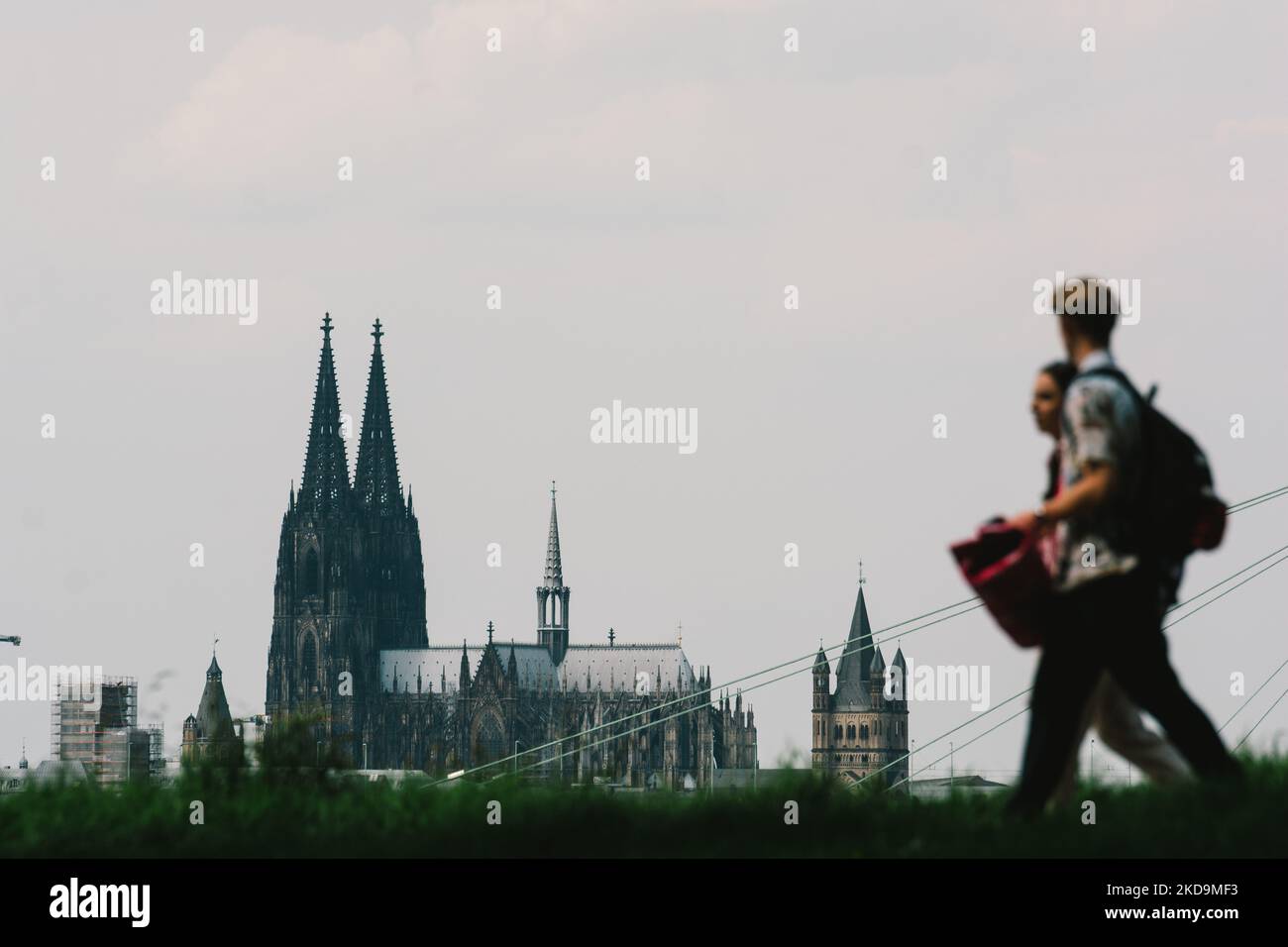 a couple is seen holding picnic blanket in front of Dom Cathedral in ...