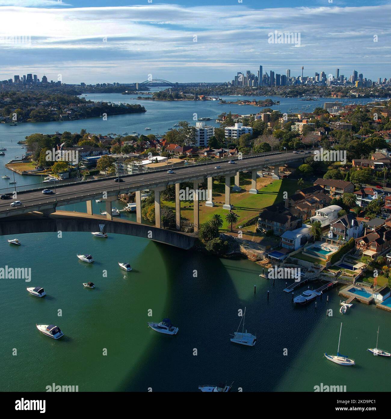 An aerial view of Gladesville bridge shadow reflecting on boats sailing ...