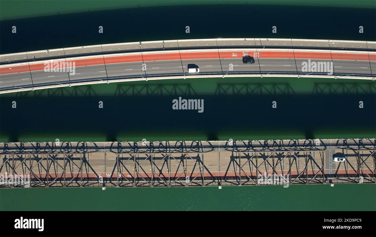 An aerial top view of cars driving on Iron Cove Bridge with shadow on ...