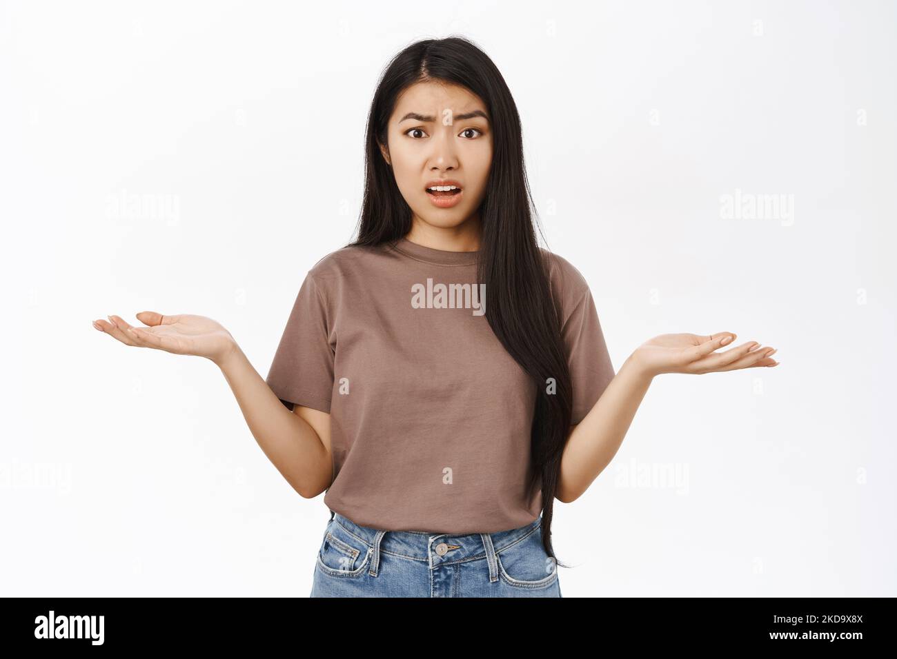 Asian woman looks confused, girl shrugs with hands spread sideways ...