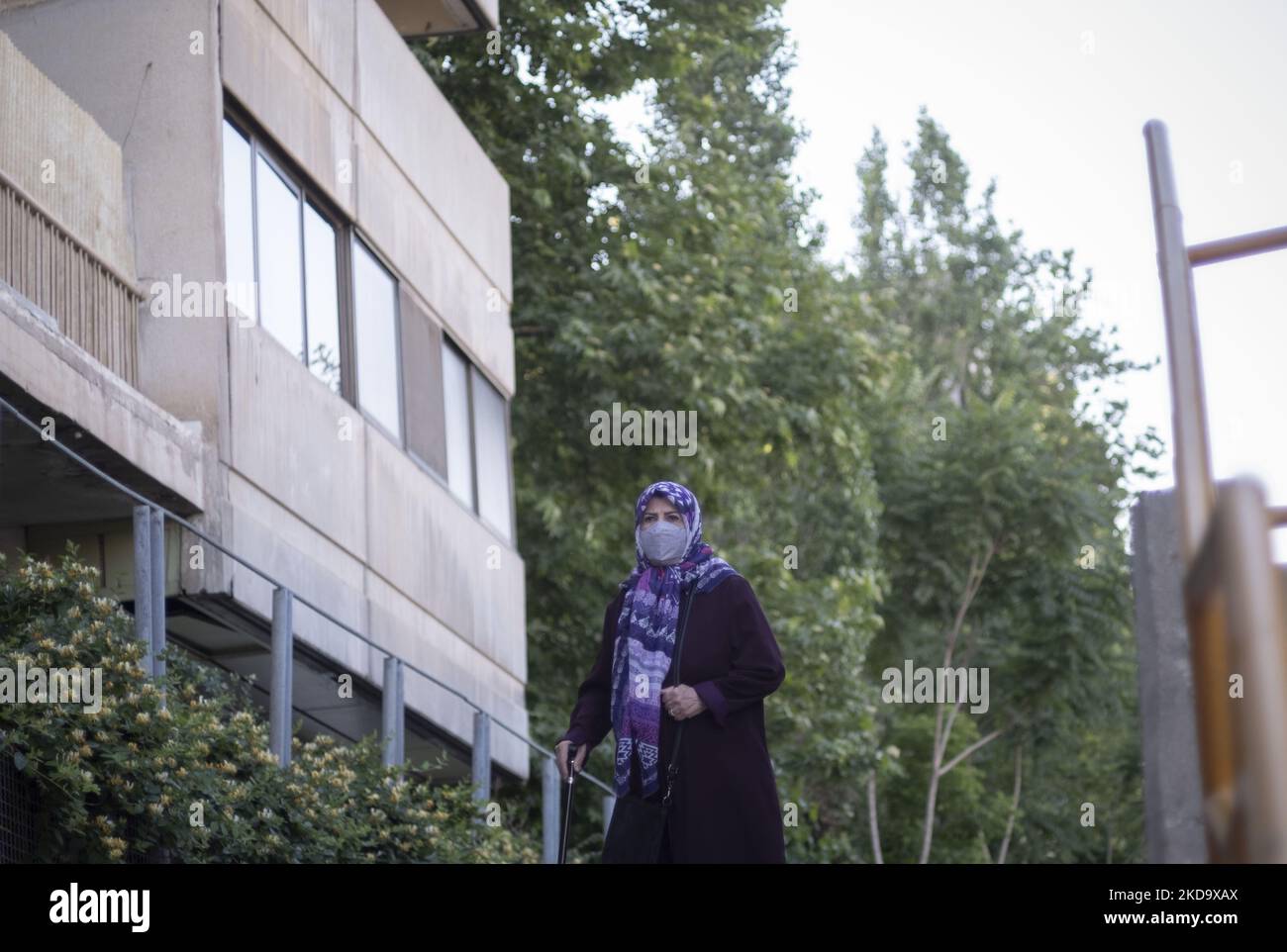 An Iranian woman looks on as she stands next to a housing complex in ...