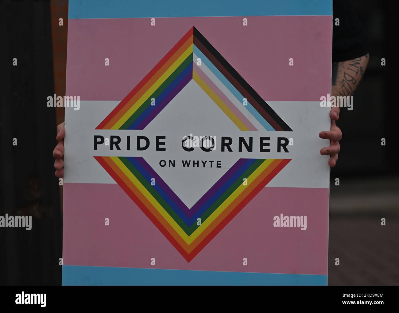 An activist holds a placard with a sign 'Pride Corner On Whyte'. More ...