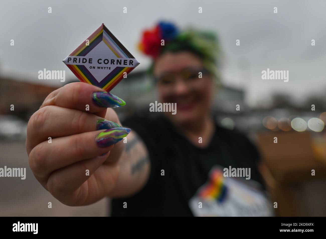 An activist holds a sign 'Pride Corner On Whyte'. More than 100 local ...