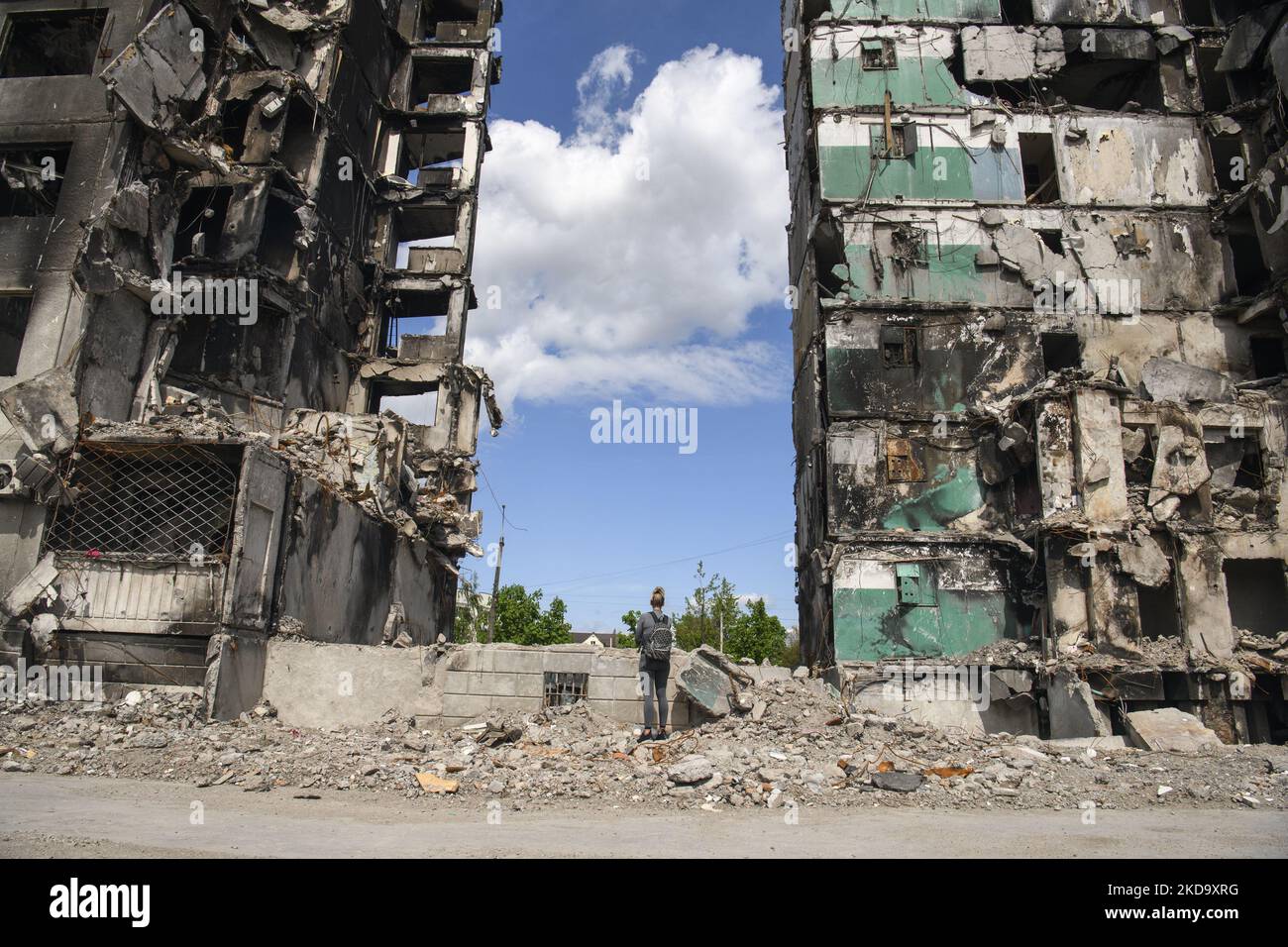 Local woman stand near her an apartment building destroyed by russian ...