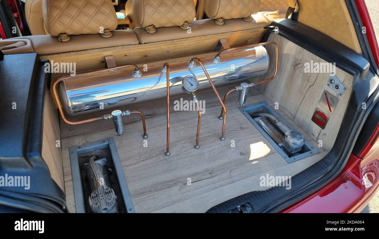 A high angle shot of hardline copper tubes and a gauge in a car trunk ...