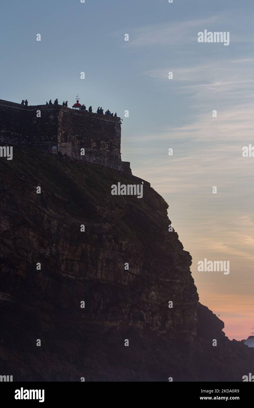 An aerial view of stony building on cliff in Nazare during sunset Stock ...