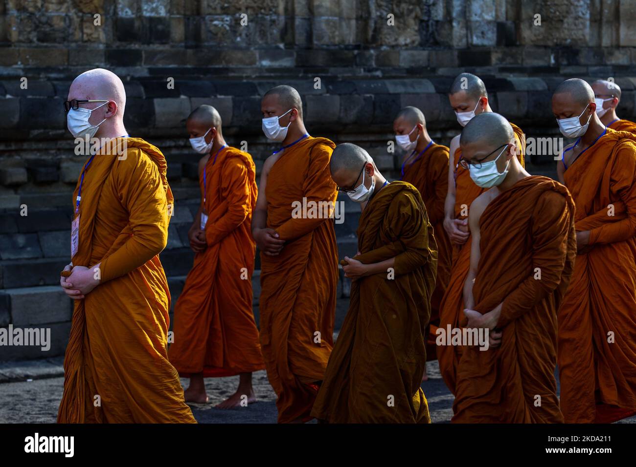 Buddhist monks walk around Mendut temple during the holy water ceremony ...