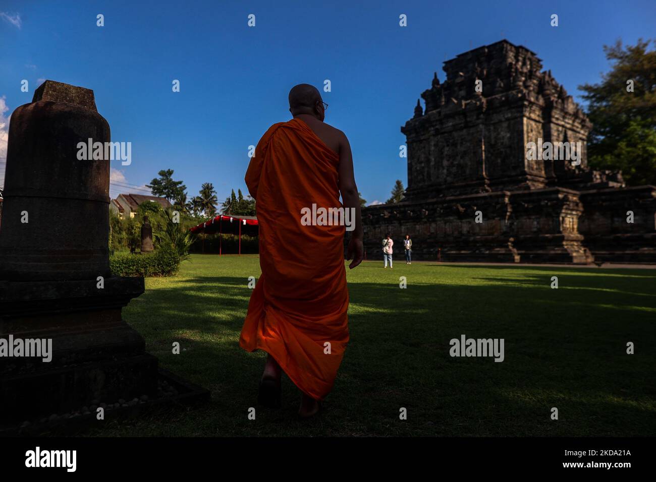 Buddhist monks walk around Mendut temple during the holy water ceremony ...