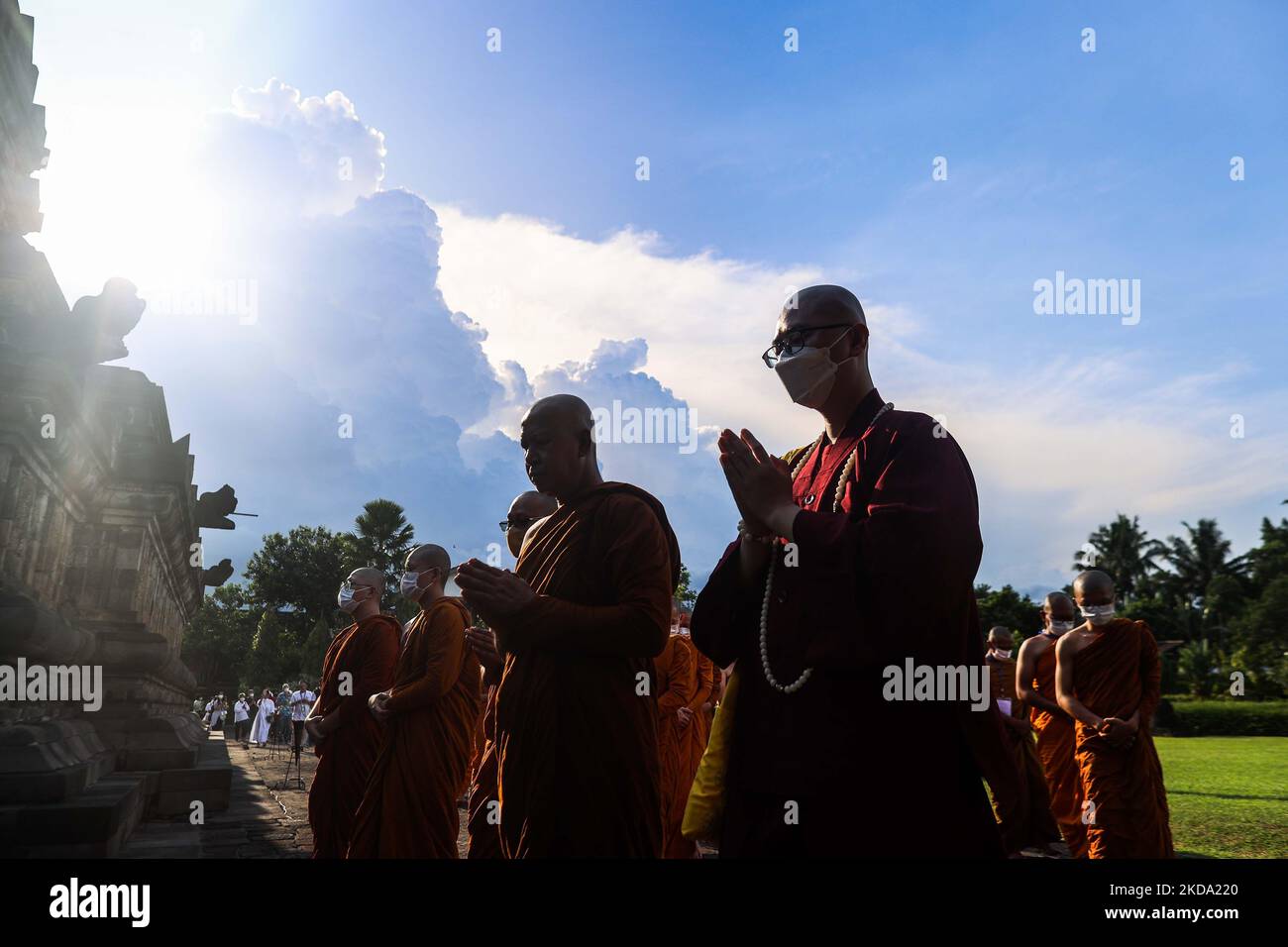 Buddhist monks walk around Mendut temple during the holy water ceremony ...