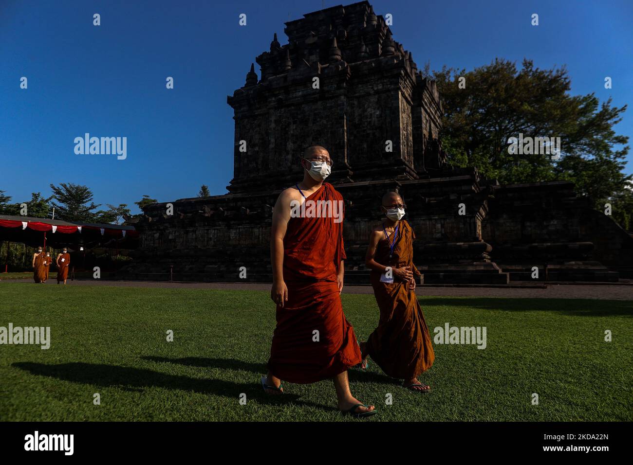 Buddhist monks walk around Mendut temple during the holy water ceremony ...