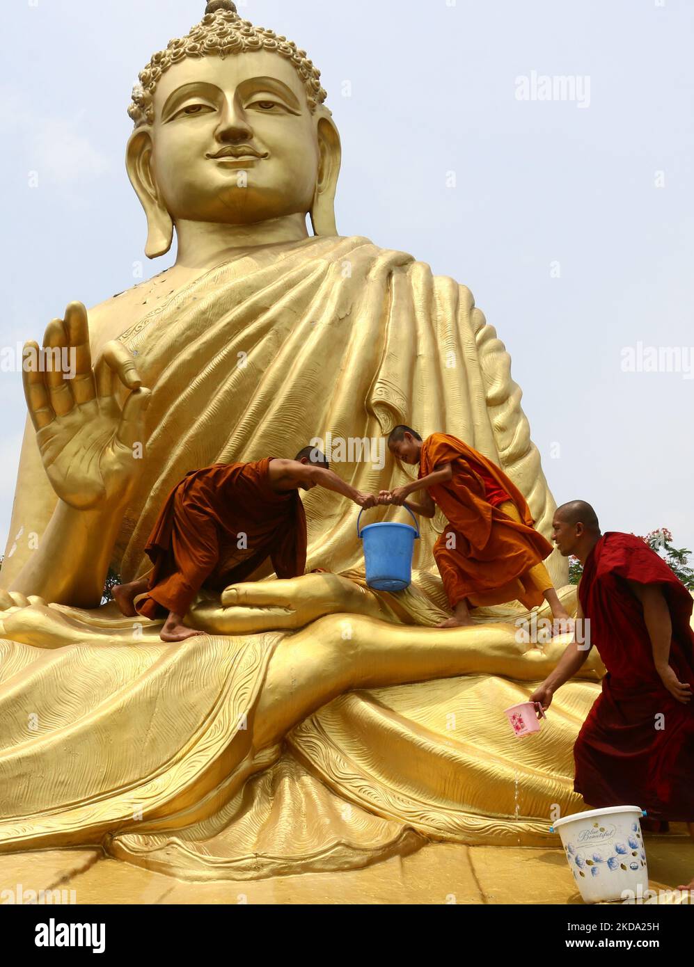 Indian Buddhist Monk Climbs Atop A Giant Statue Of Buddha To Wash And Indian Buddhist Monk Climbs Atop A Giant Statue Of Buddha To Wash And