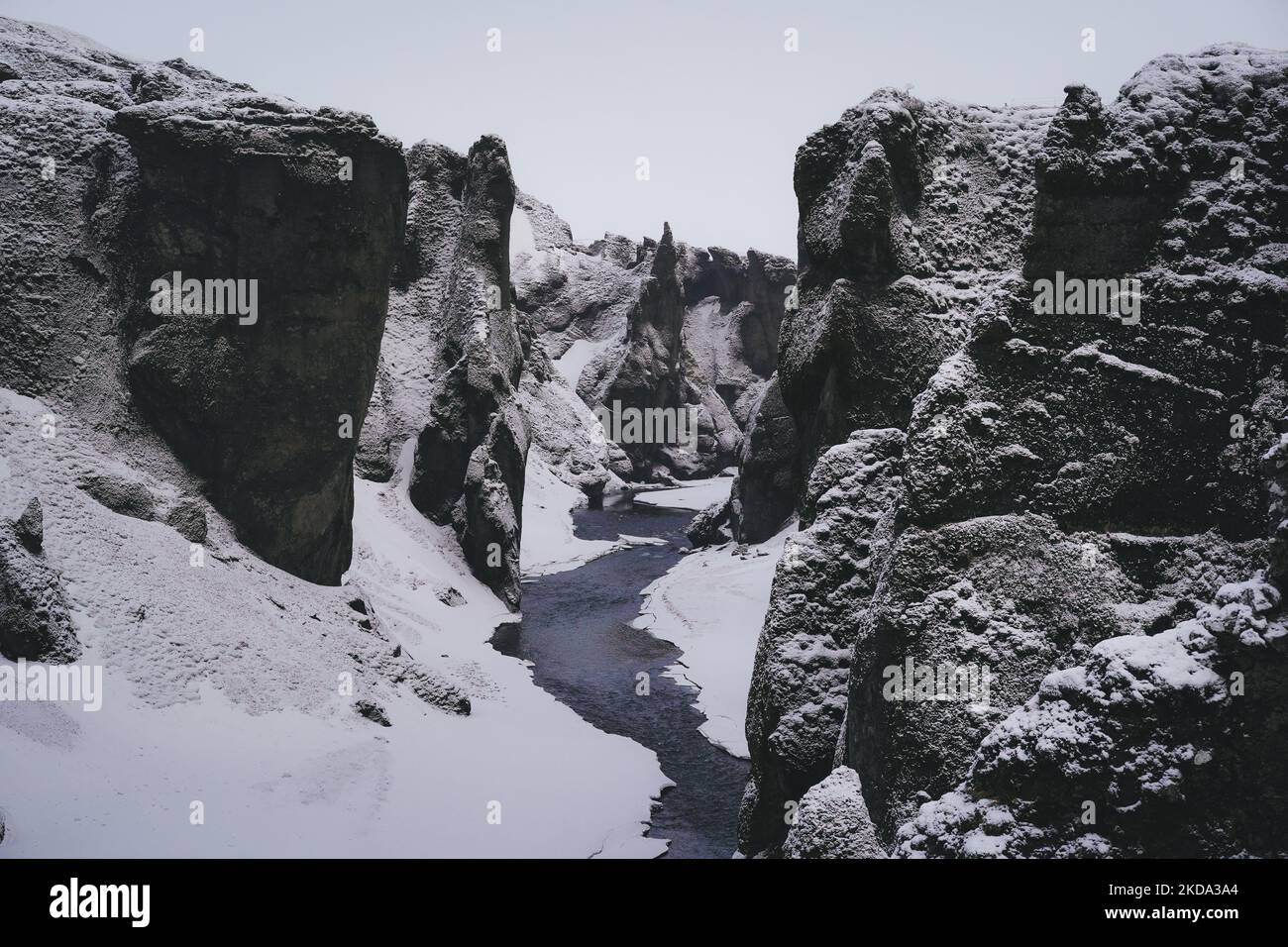 A flowing river surrounded by snow covered rocks Stock Photo - Alamy