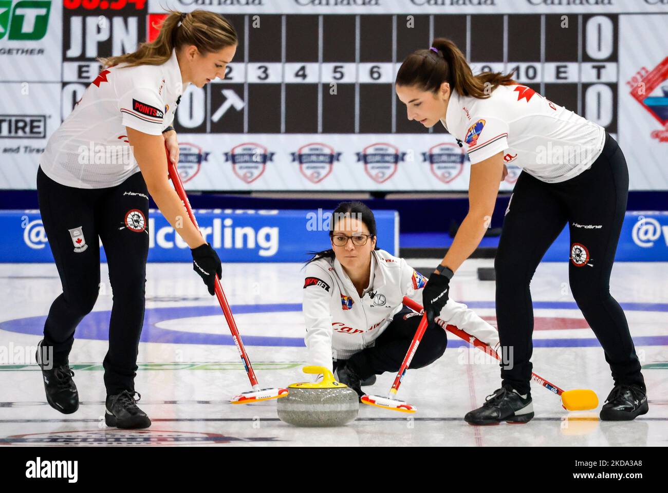 Canada skip Kerri Einarson, centre, makes a shot as lead Briane Harris ...