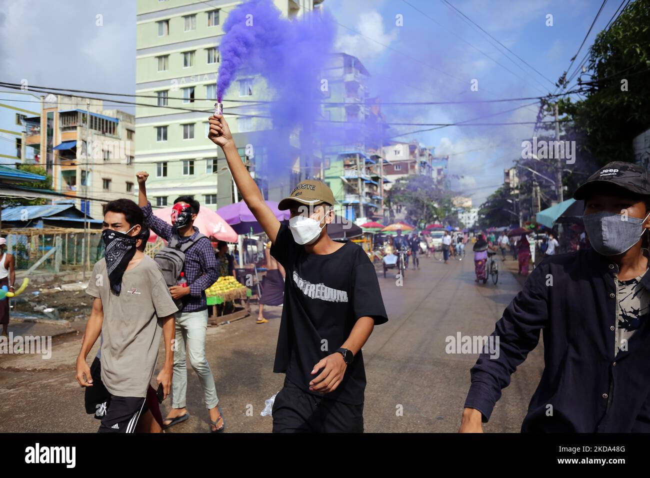 A young demonstrator lights a flare during an anti-coup protest in ...