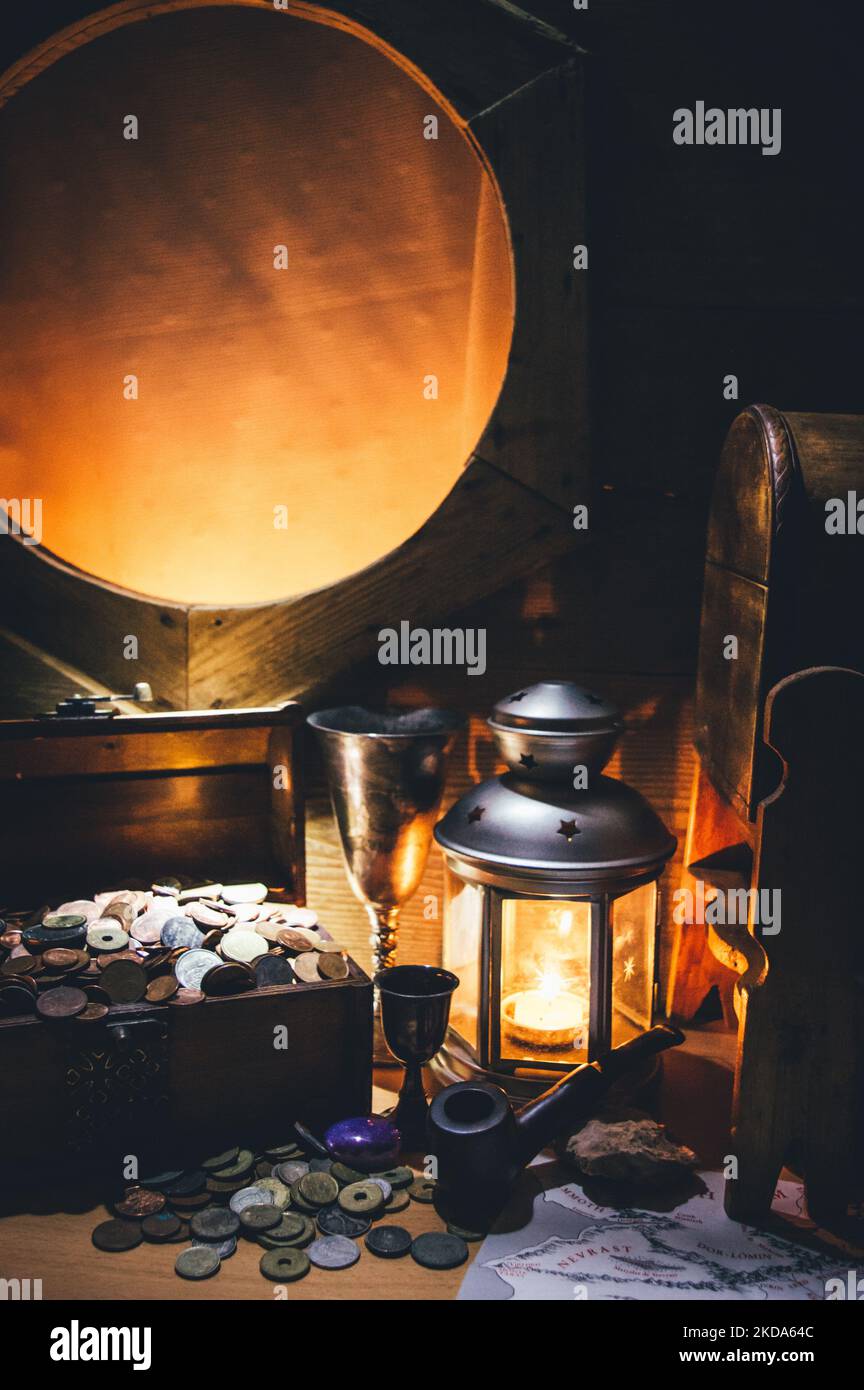A vertical of many old coins gathered in a wooden chest next to an ...